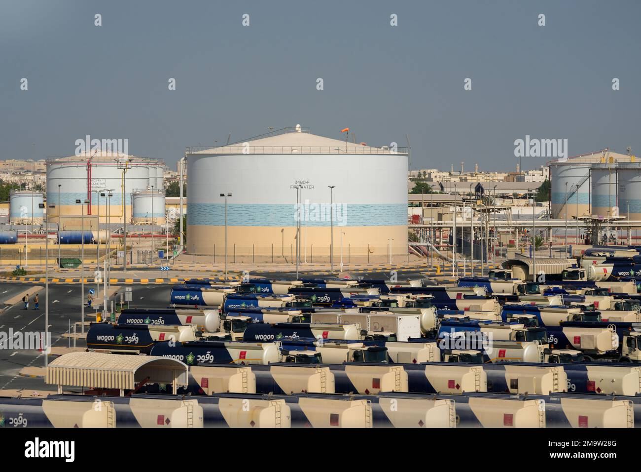 Fuel trucks line up in front of storage tanks in Doha, Qatar, Thursday ...