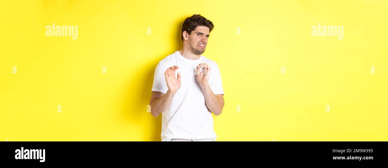 Digusted guy refusing and grimacing, looking at something with aversion ...