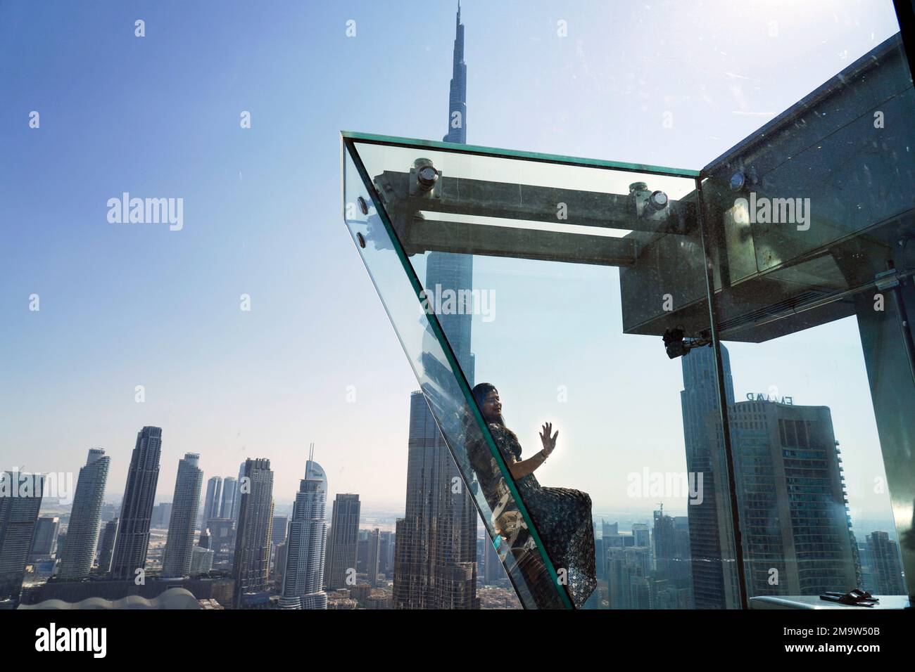 A woman poses for a photograph with the Burj Khalifa, the world's ...
