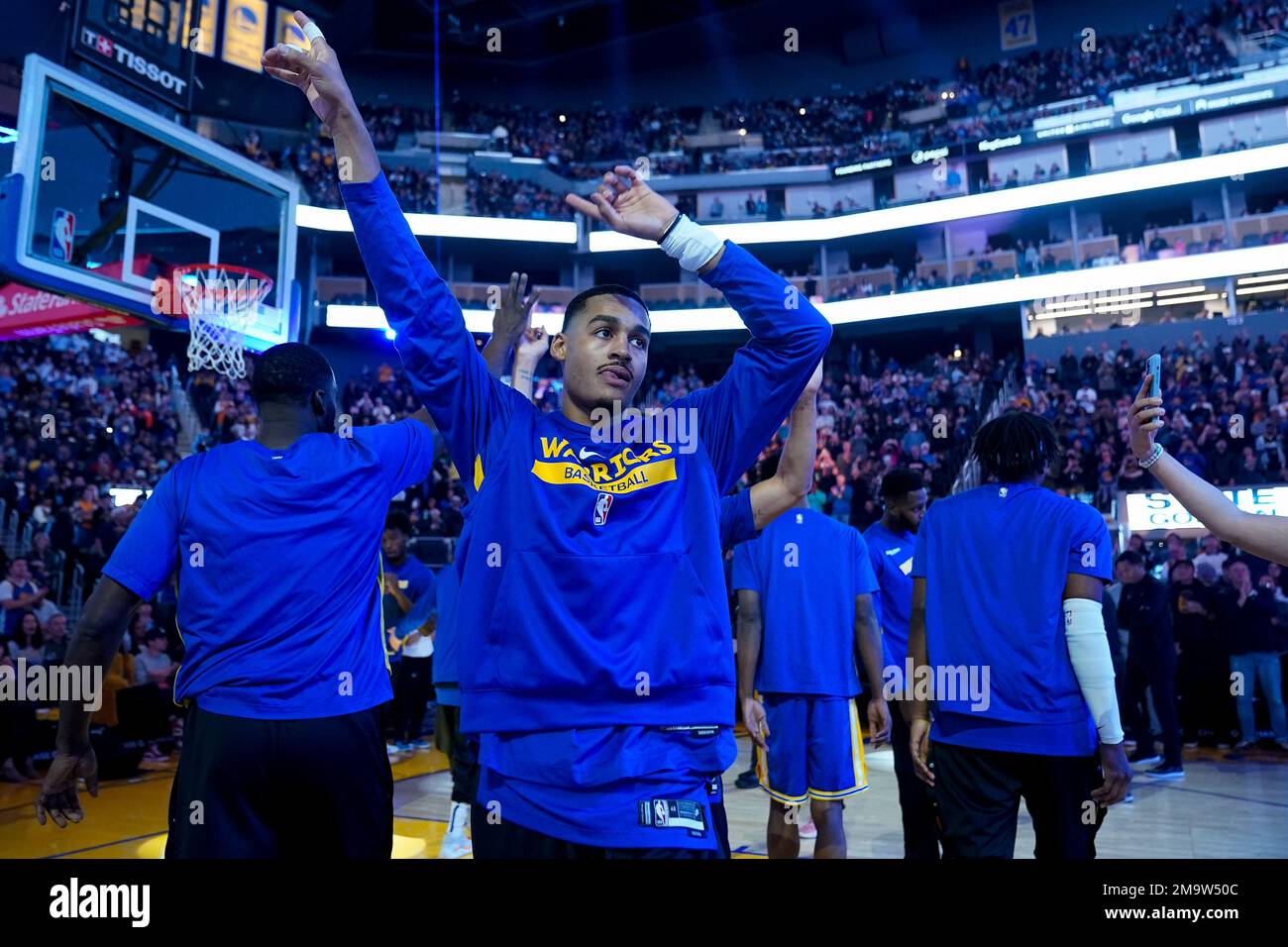 Golden State Warriors guard Jordan Poole, middle, takes the court for ...