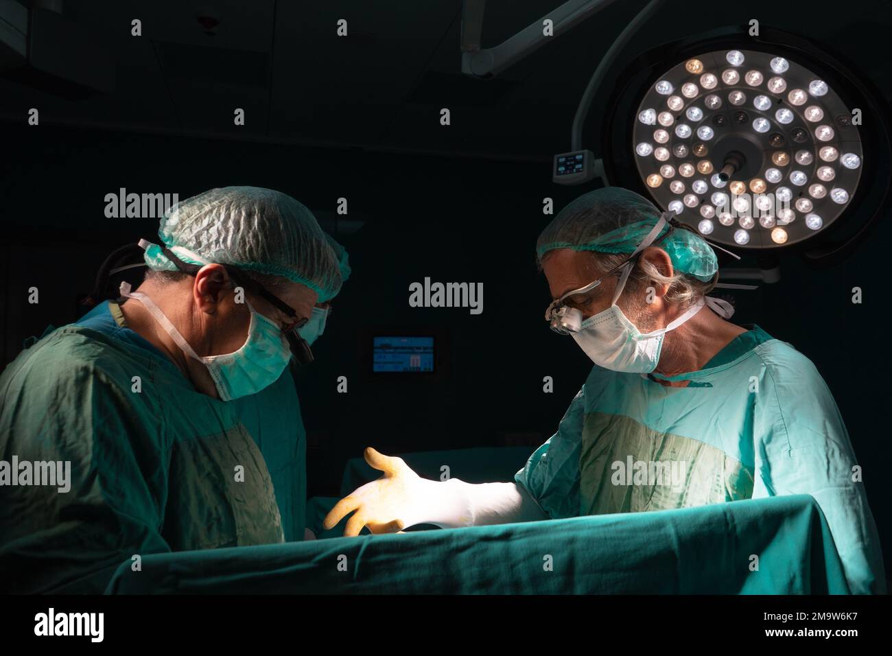 Open heart surgery doctor perform open heart surgery. Doctors in green uniforms are in the ...