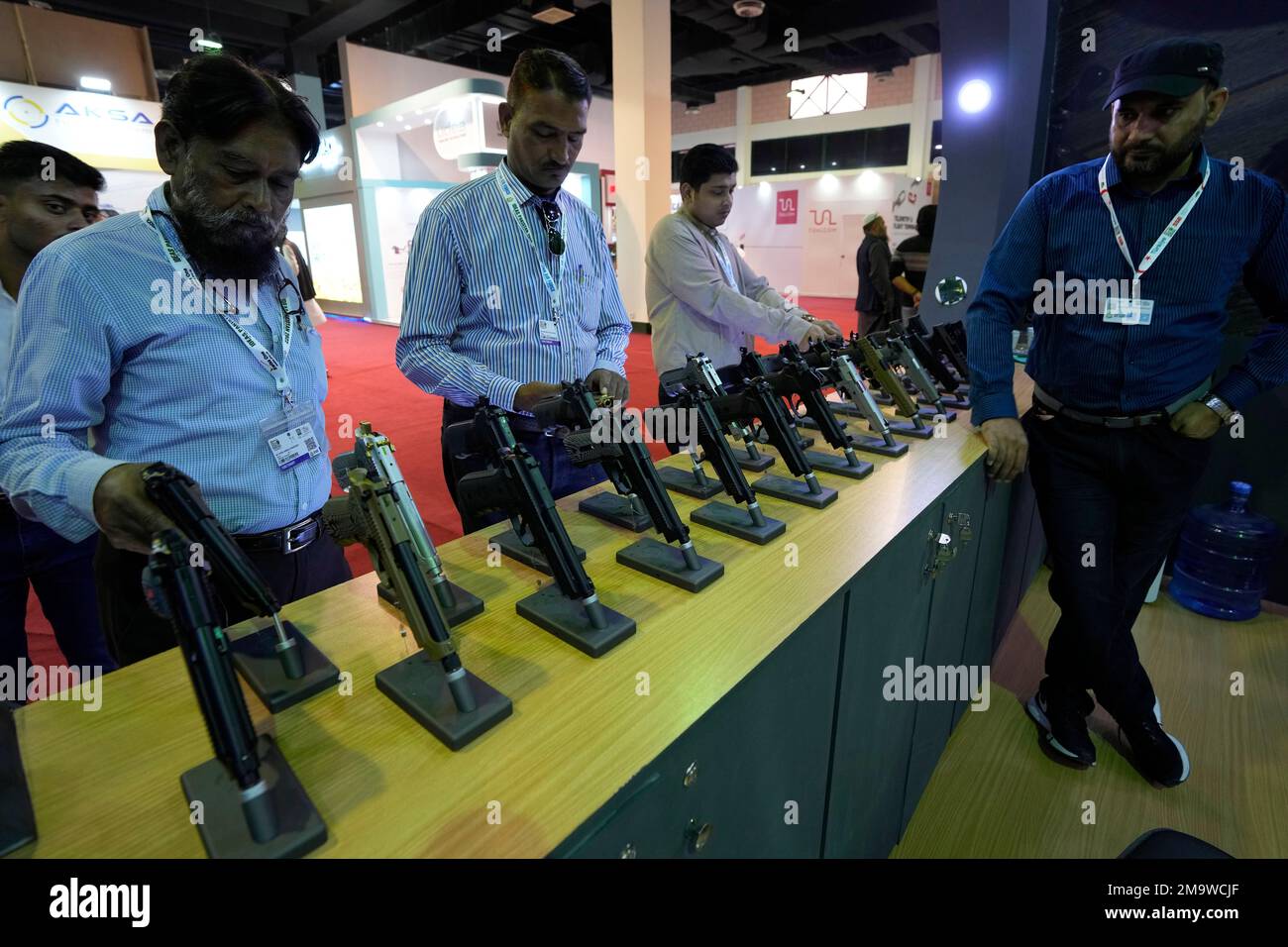 People view a variety of handguns at a defense exhibition in Karachi ...