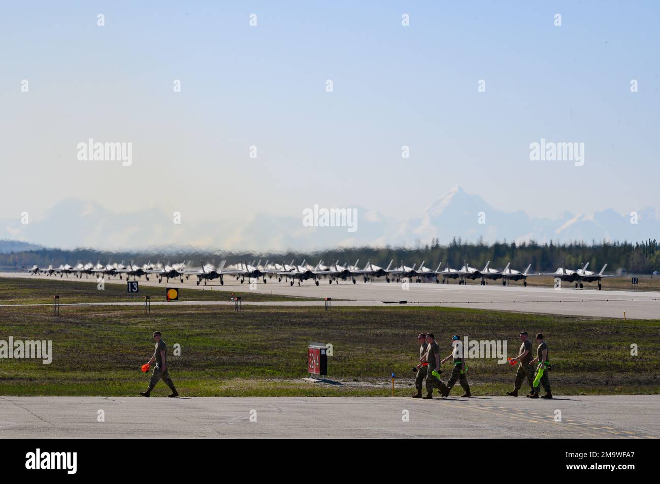 U.S. Airmen assigned to the 354th Fighter Wing walk on the flightline ...