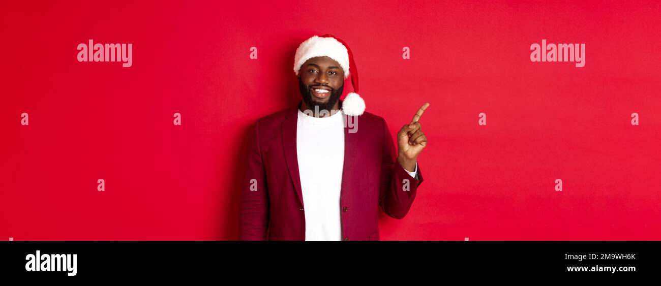 Christmas, party and holidays concept. Handsome Black man in santa hat ...