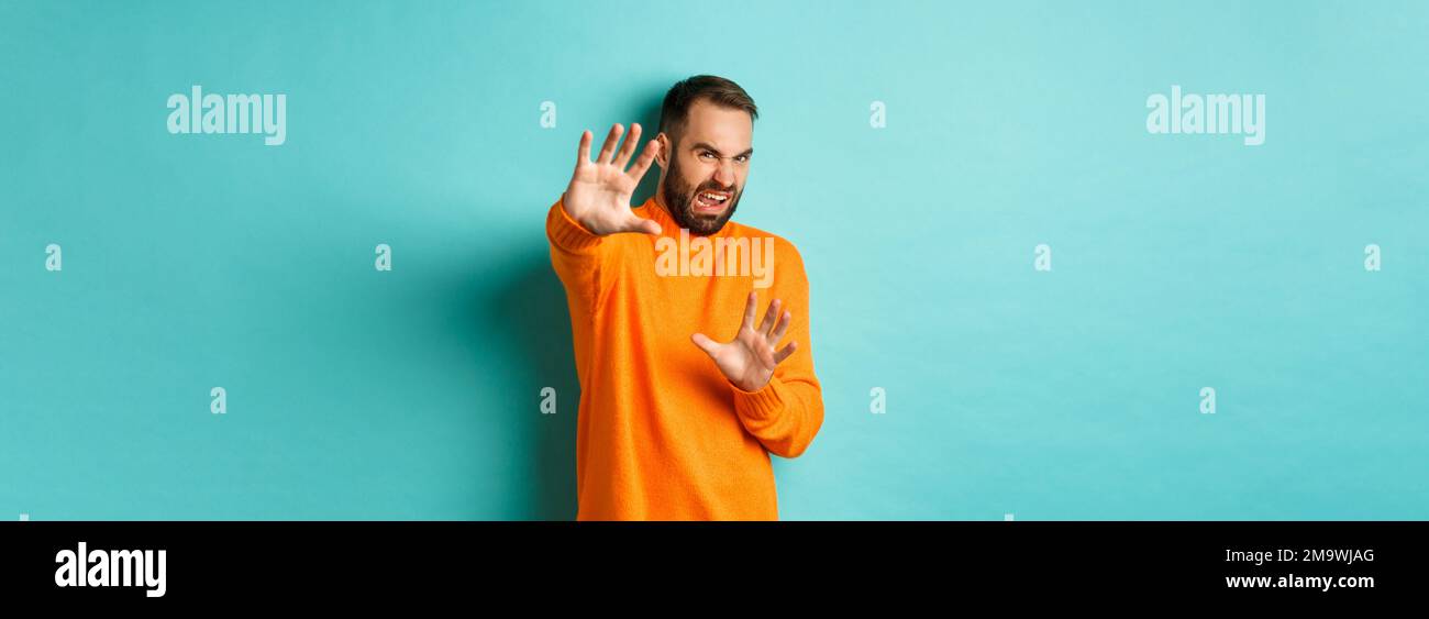 Disgusted man cringe and extending hands in protection, begging for ...