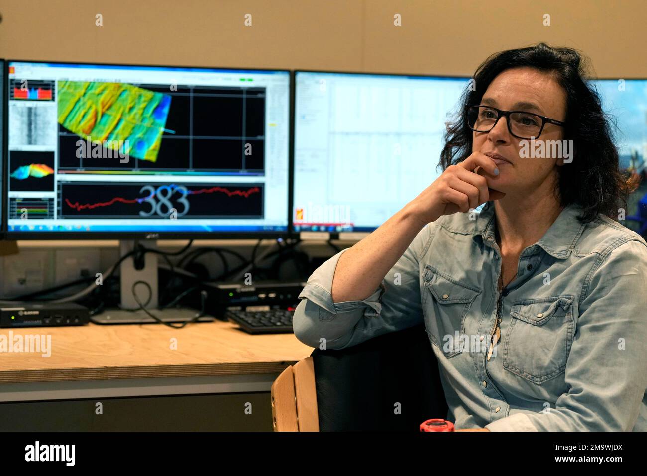 Kelly Hogan a marine geophysicist with a display of part of the ...