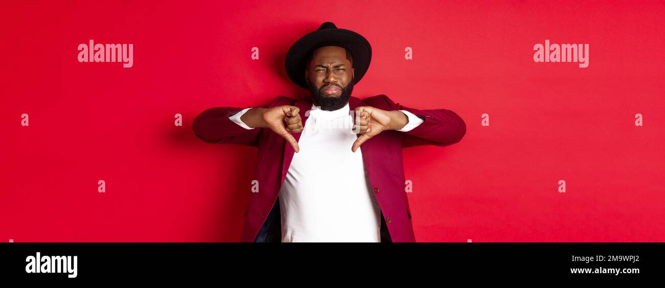 Disappointed Black man leave negative feedback, showing thumb down and ...