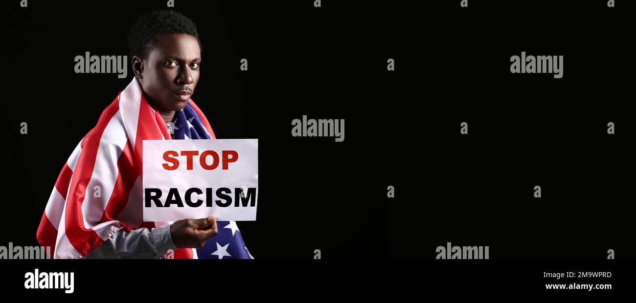 African-American man with poster and national flag of USA on dark ...