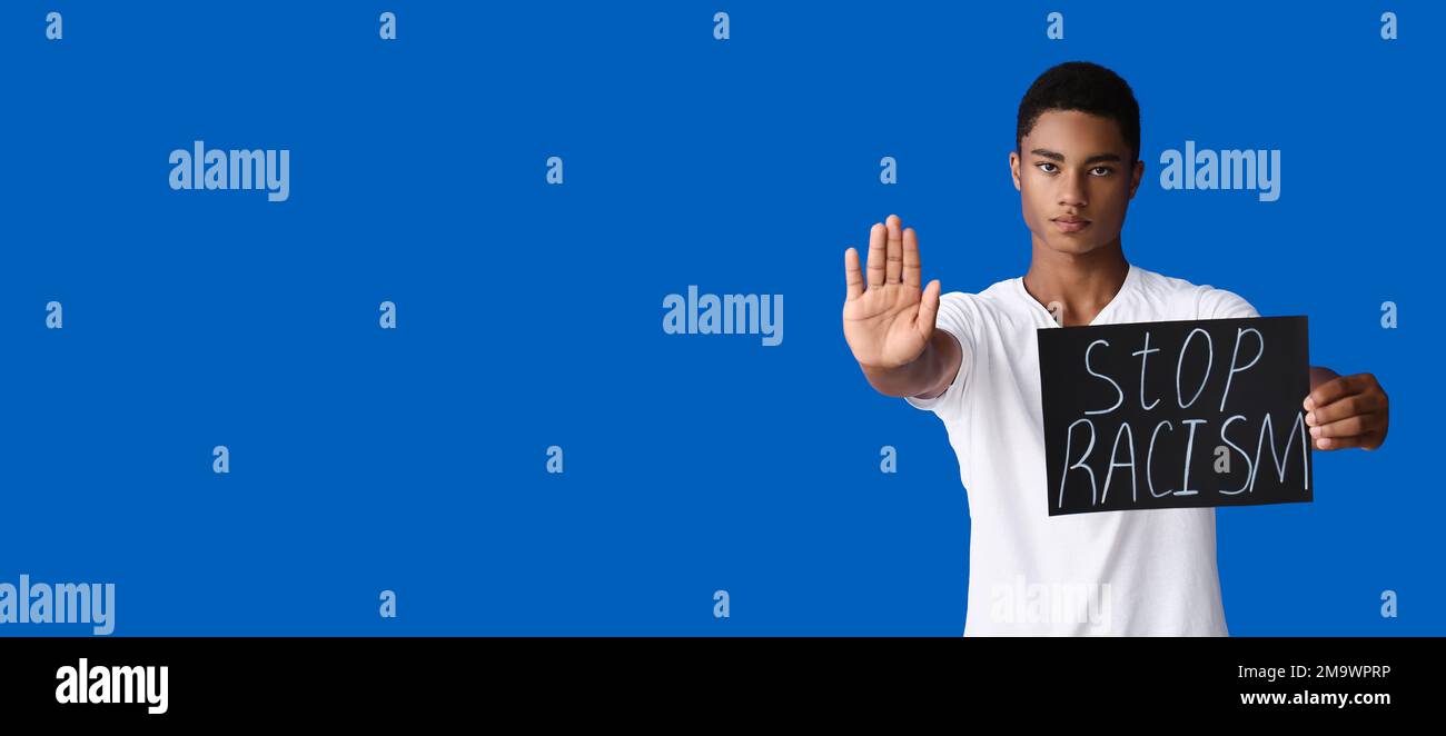 African-American teenage boy holding poster with text STOP RACISM on ...