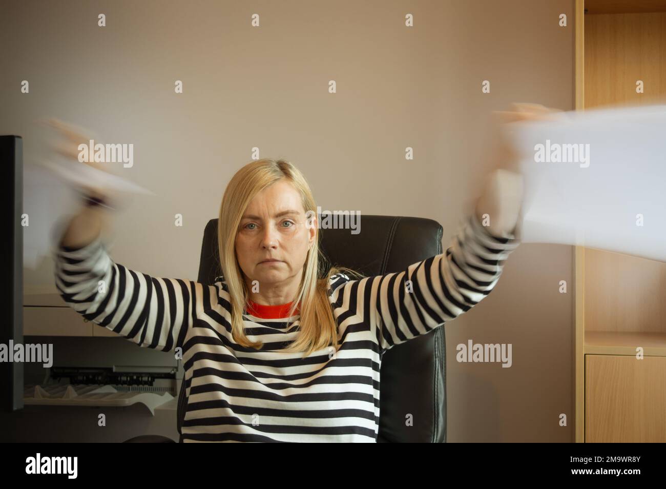 Shocked woman among papers in the office Stock Photo - Alamy