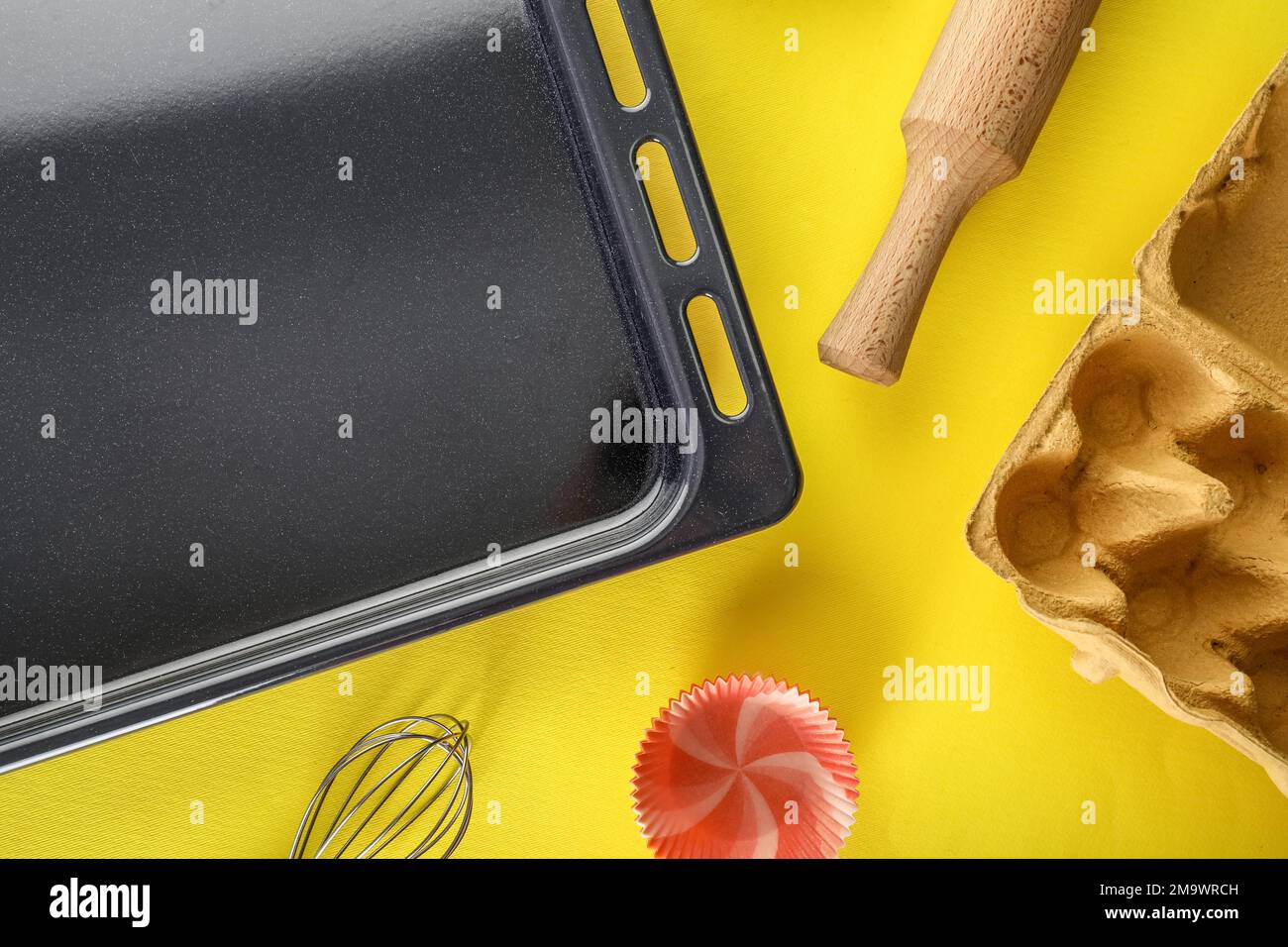 Baking tray with utensils on yellow background Stock Photo - Alamy