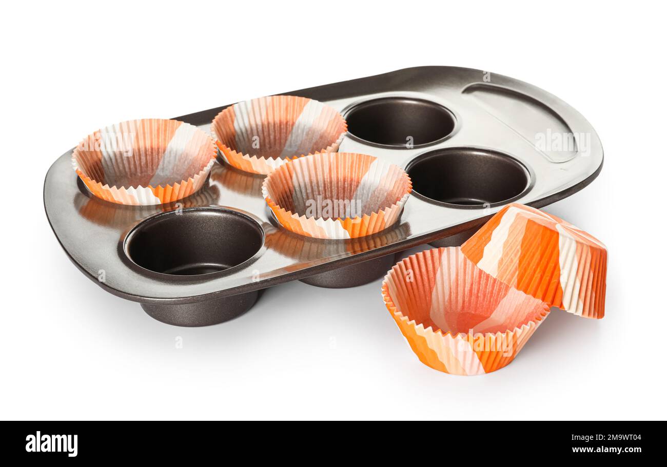 Muffin baking tray with paper forms on white background Stock Photo - Alamy