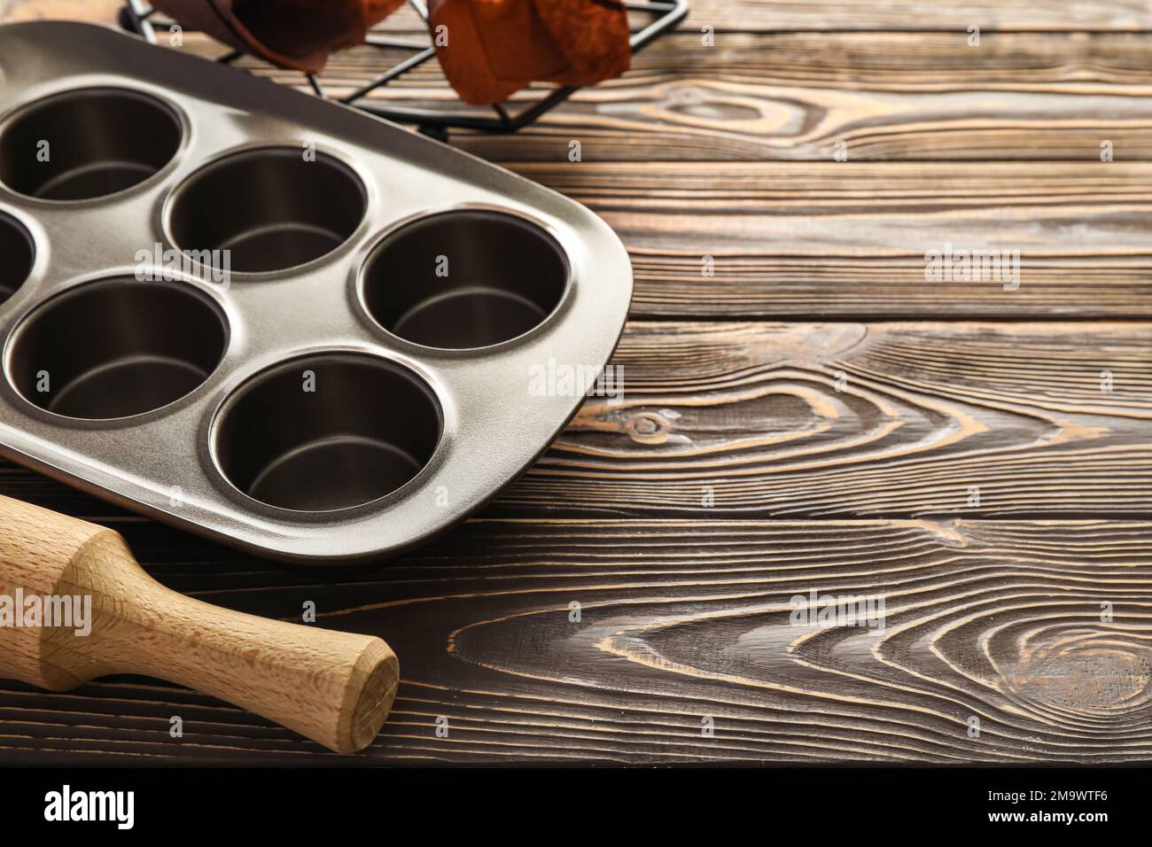 Muffin tray and rolling pin on wooden background Stock Photo - Alamy