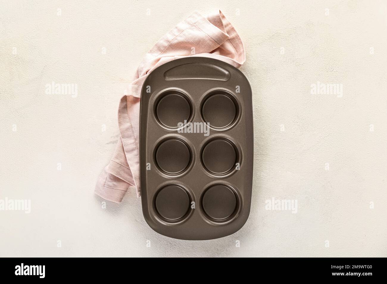 Muffin tray and napkin on light background Stock Photo - Alamy