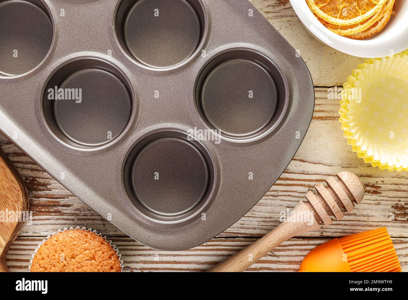 Muffin tray on light wooden table, closeup Stock Photo - Alamy