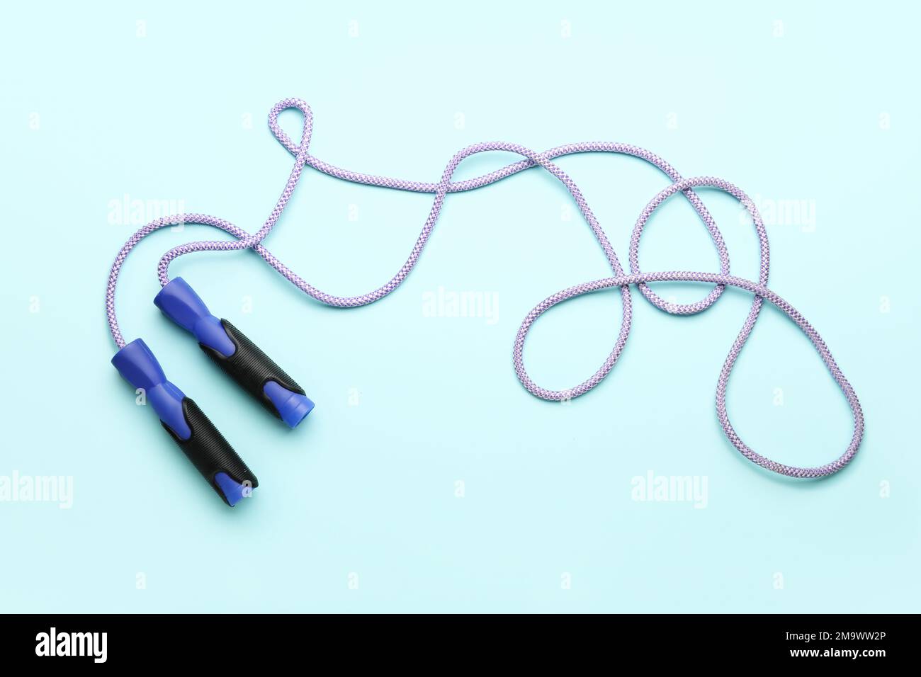 Skipping rope on blue background Stock Photo - Alamy
