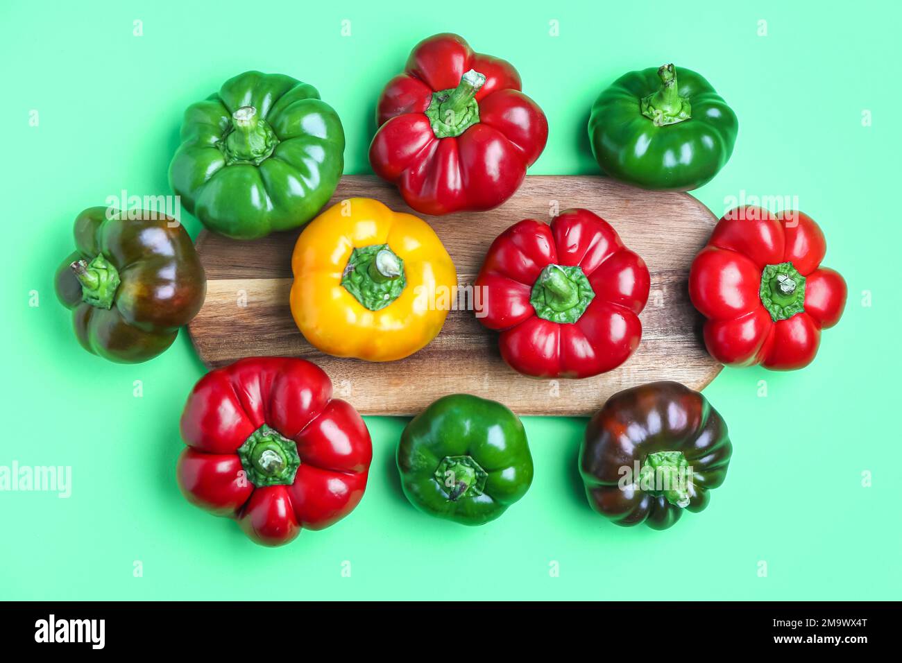 Board with bell peppers on color background Stock Photo - Alamy