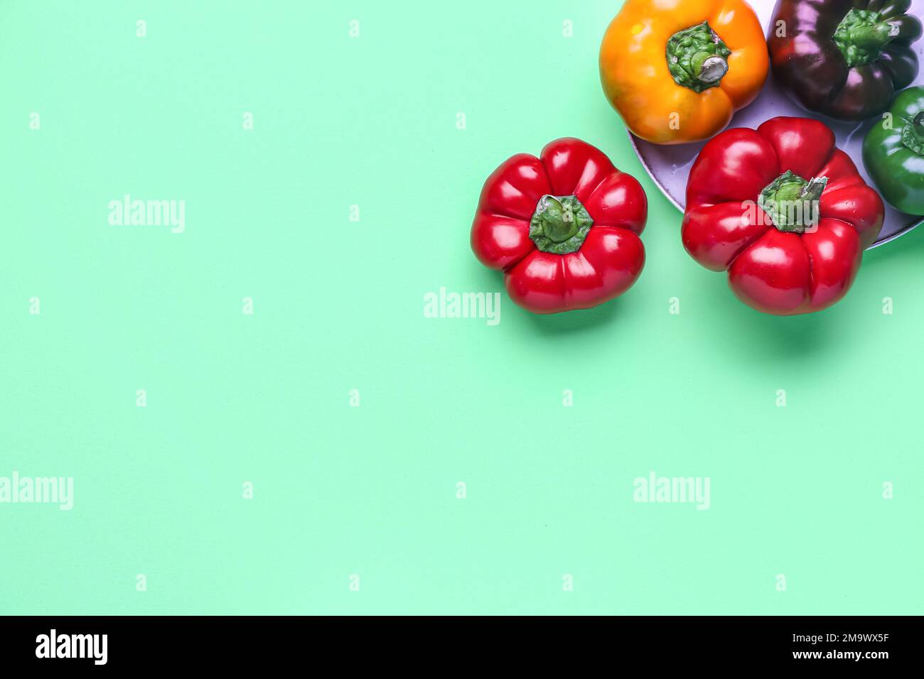 Plate with fresh bell peppers on color background Stock Photo - Alamy