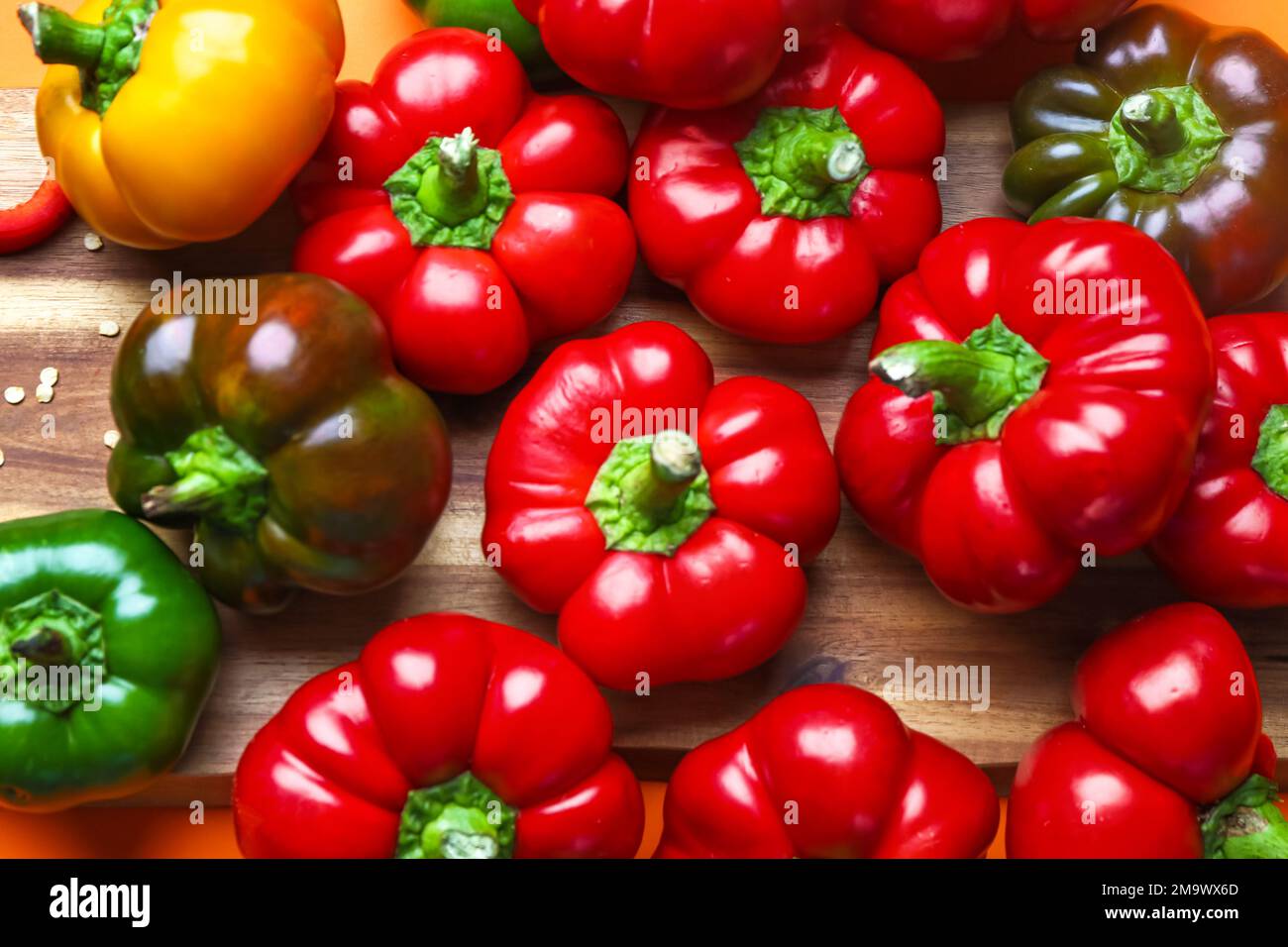 Wooden board with fresh bell peppers on color background, closeup Stock ...