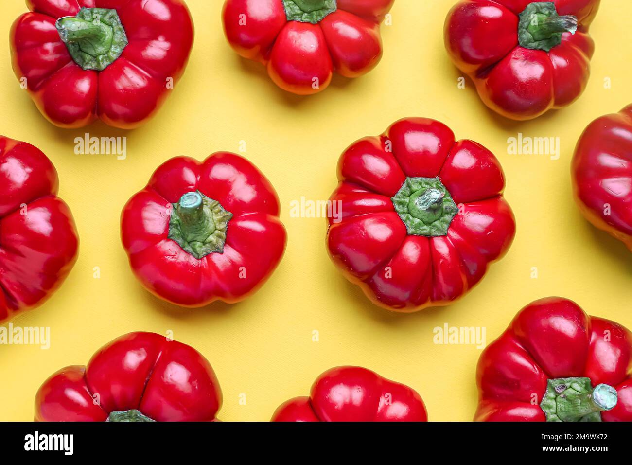 Composition with red bell peppers on yellow background Stock Photo - Alamy