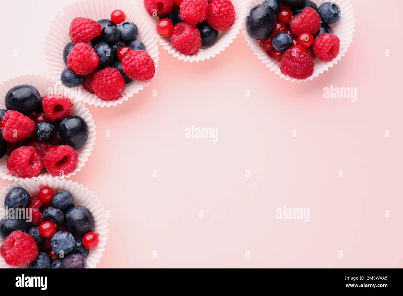 Paper baking cups with fresh berries on color background Stock Photo ...