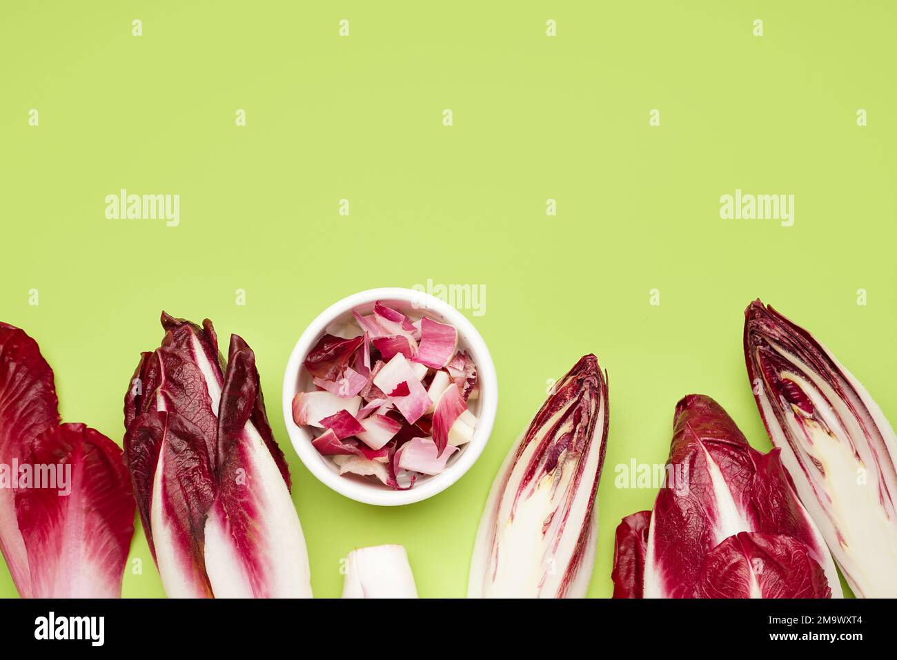Composition with whole and cut red endive on green background Stock ...