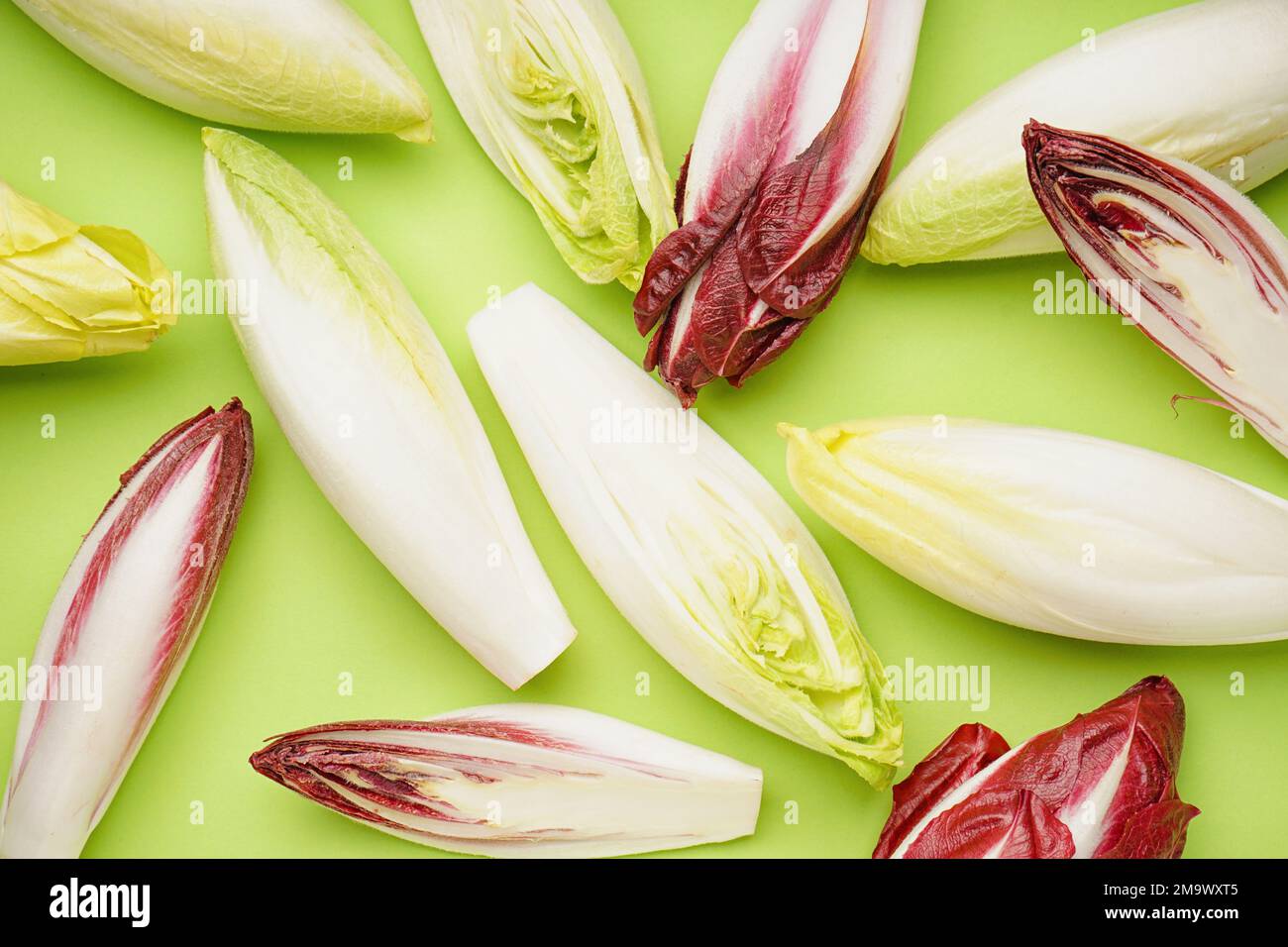 Bunches of different fresh endive on green background Stock Photo - Alamy