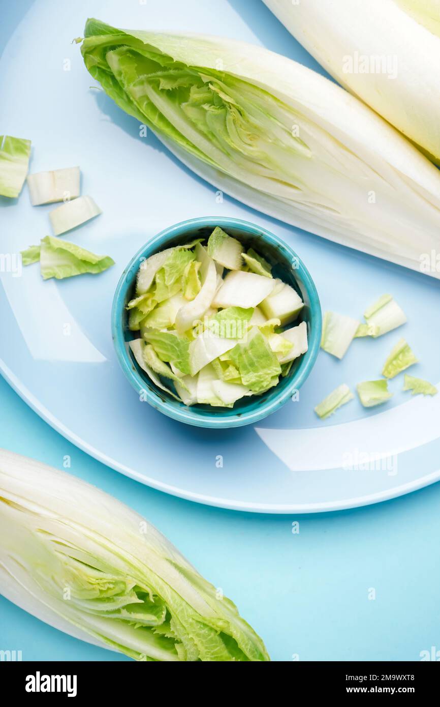 Plate with cut fresh endive on color background, closeup Stock Photo ...