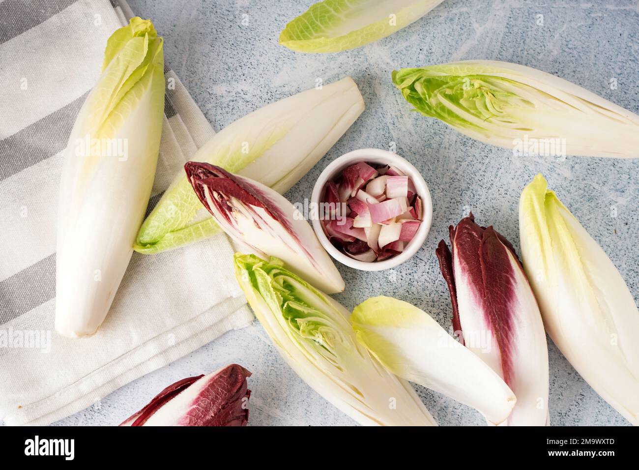 Composition with whole and cut endive on light background Stock Photo ...