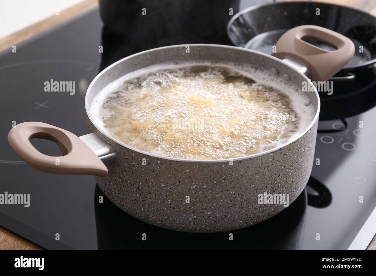 Cooking pot with boiling pasta on stove, closeup Stock Photo - Alamy