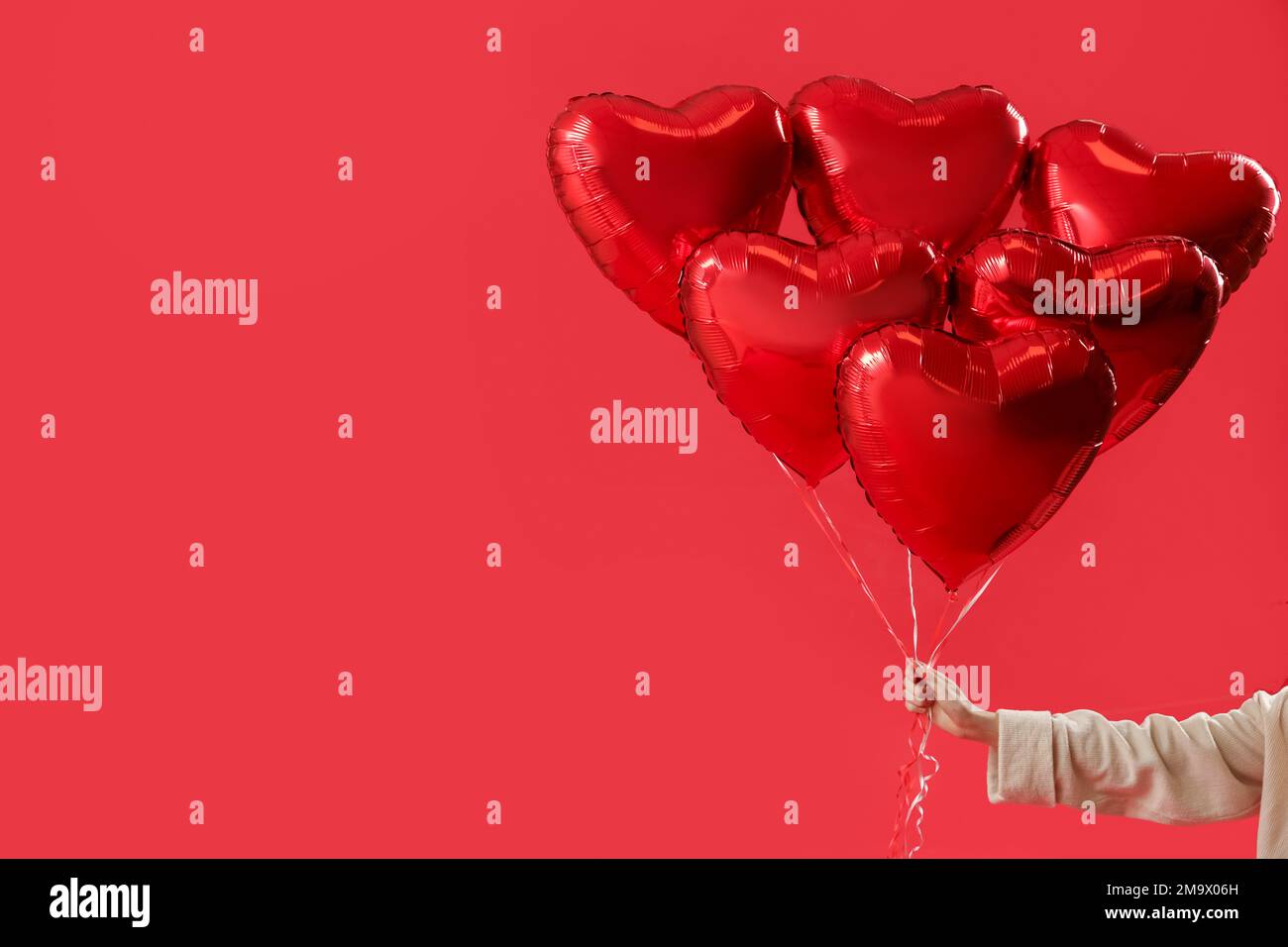Woman with heart shaped balloons for Valentine's Day on red background ...
