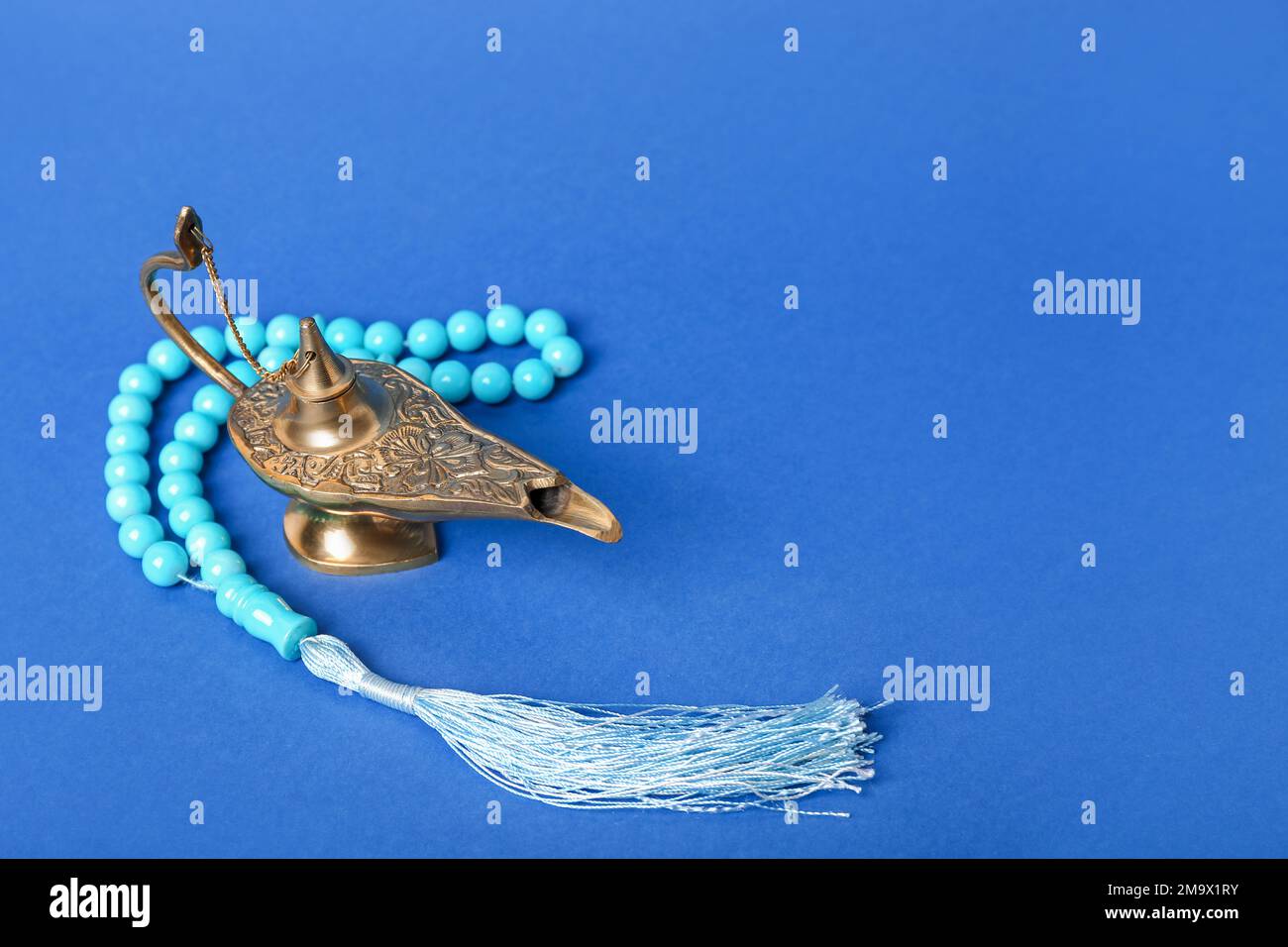 Aladdin lamp of wishes and prayer beads for Ramadan on blue background ...
