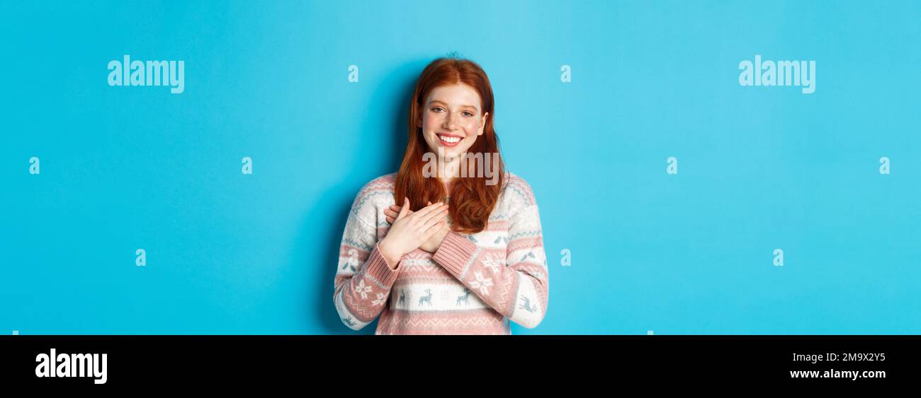 Image of beautiful redhead female model holding hands on heart and ...