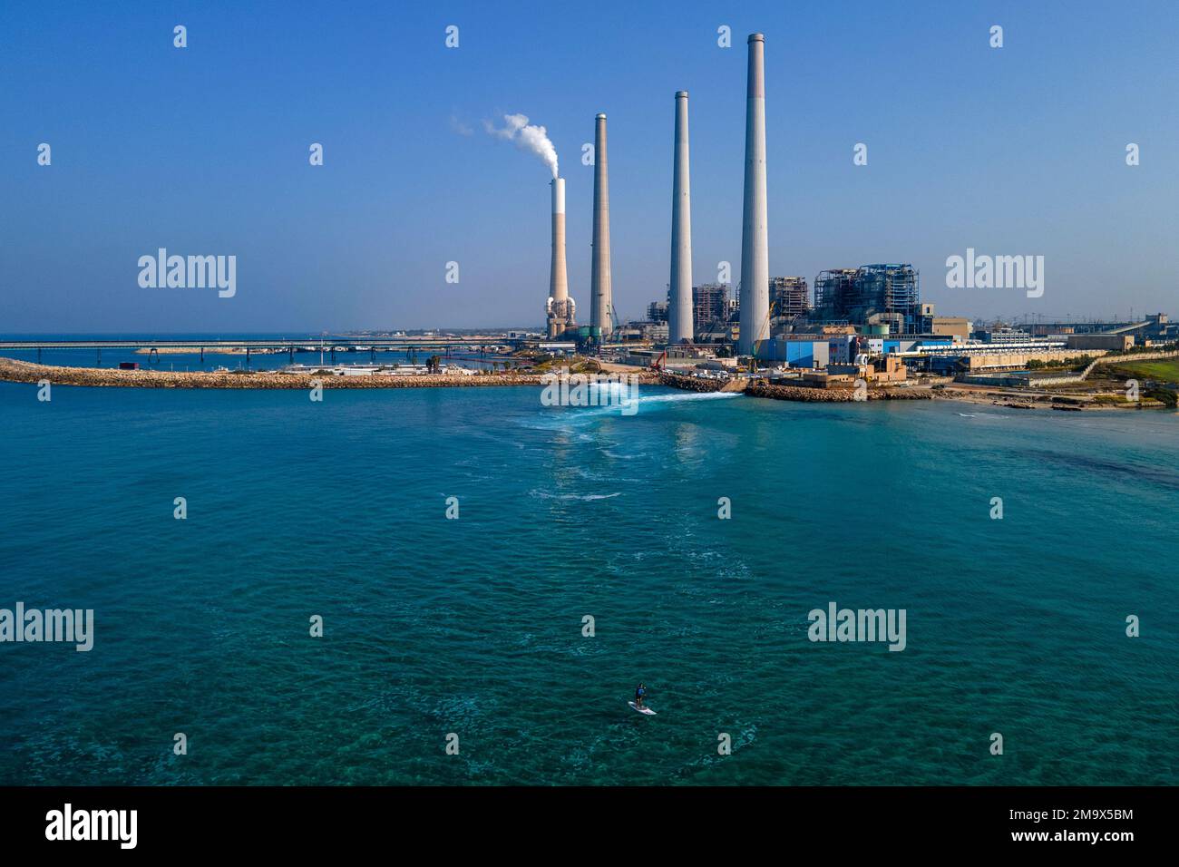 A person paddles on a board past Orot Rabin power station on the ...