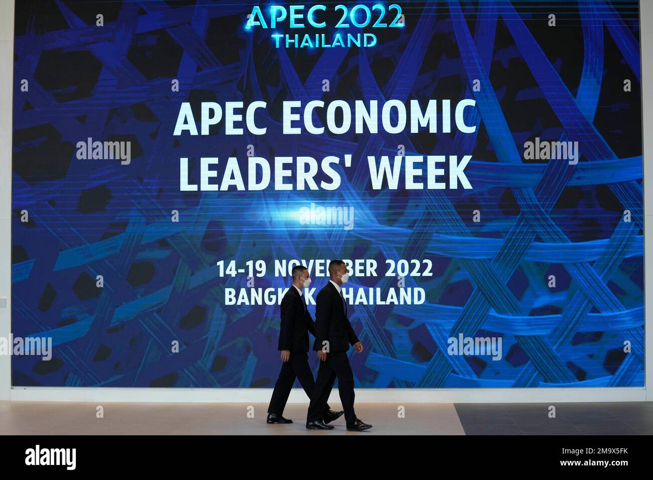 Thai officers walk in front of a sign of Asia-Pacific Economic ...