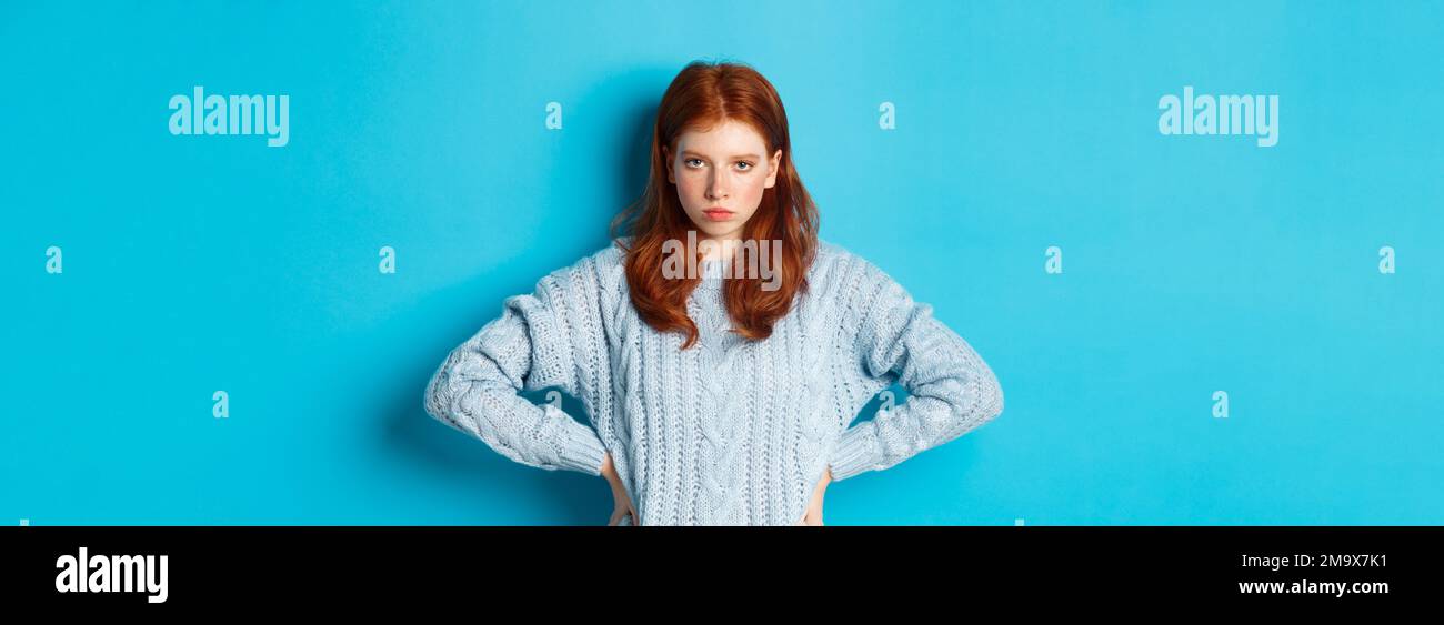 Redhead girl staring angry and displeased at camera, frowning upset ...