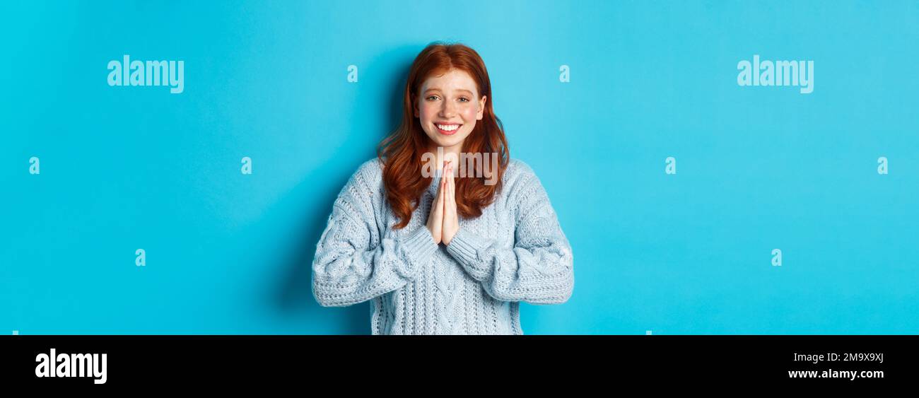 Cute redhead girl saying thank you, smiling and looking at camera ...