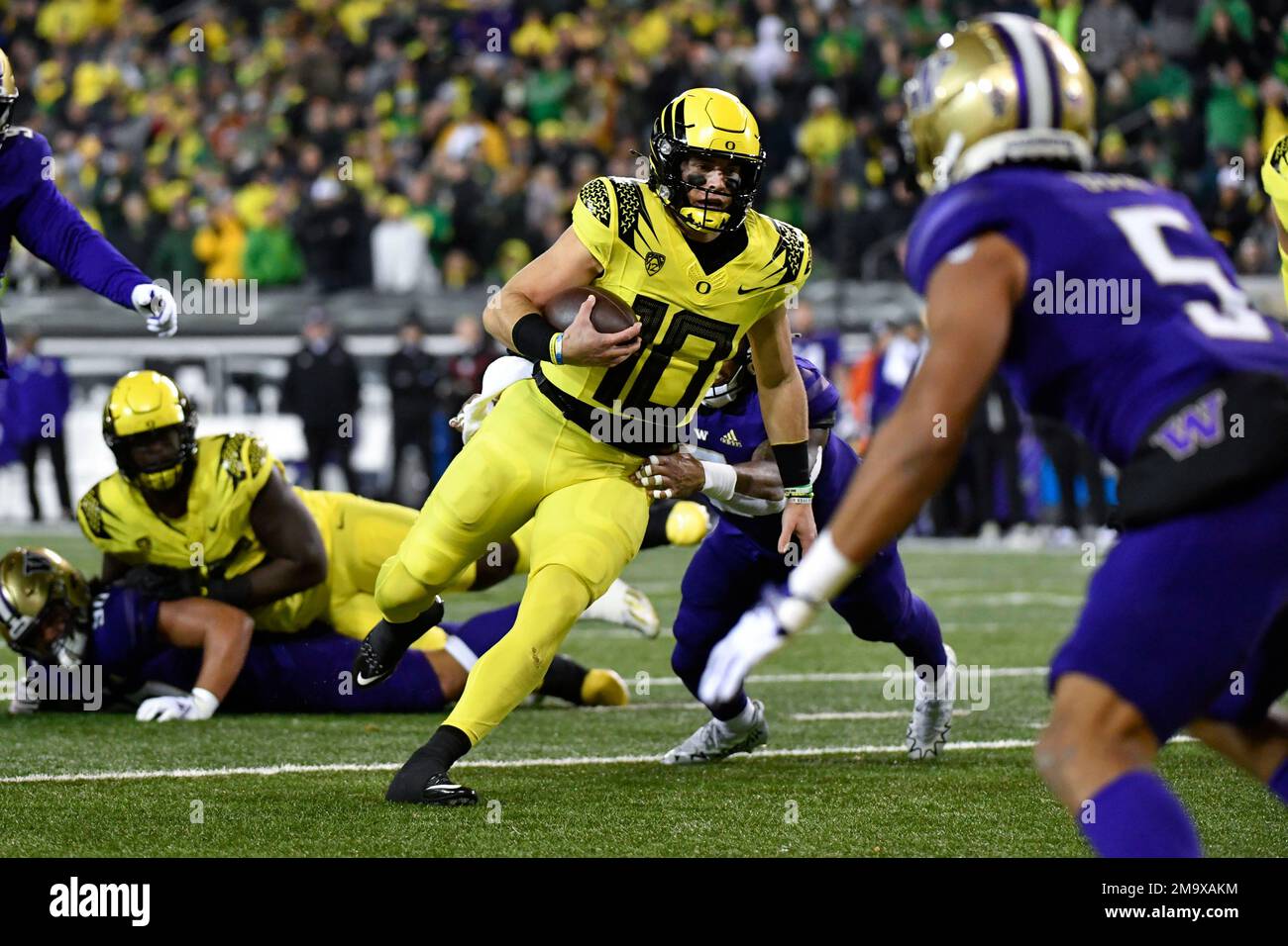 Oregon quarterback Bo Nix (10) runs past Washington defenders during ...