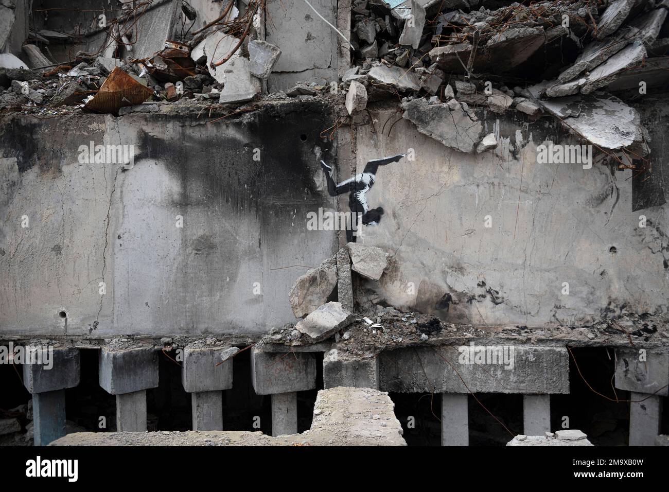 A painting by British street artist Banksy is seen on a building destroyed by fighting in ...