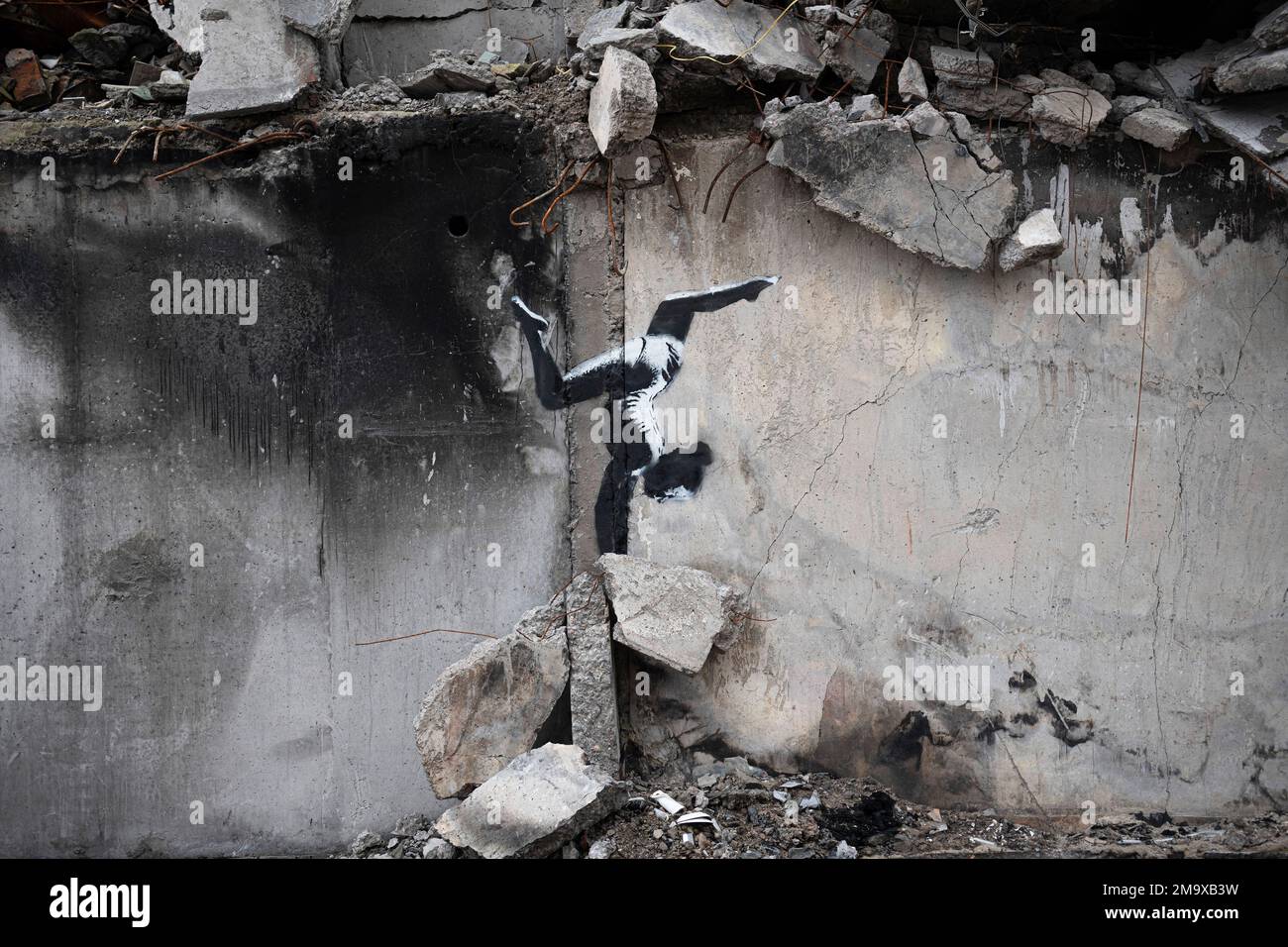 An artwork by British street artist Banksy is seen on a building destroyed by fighting in ...