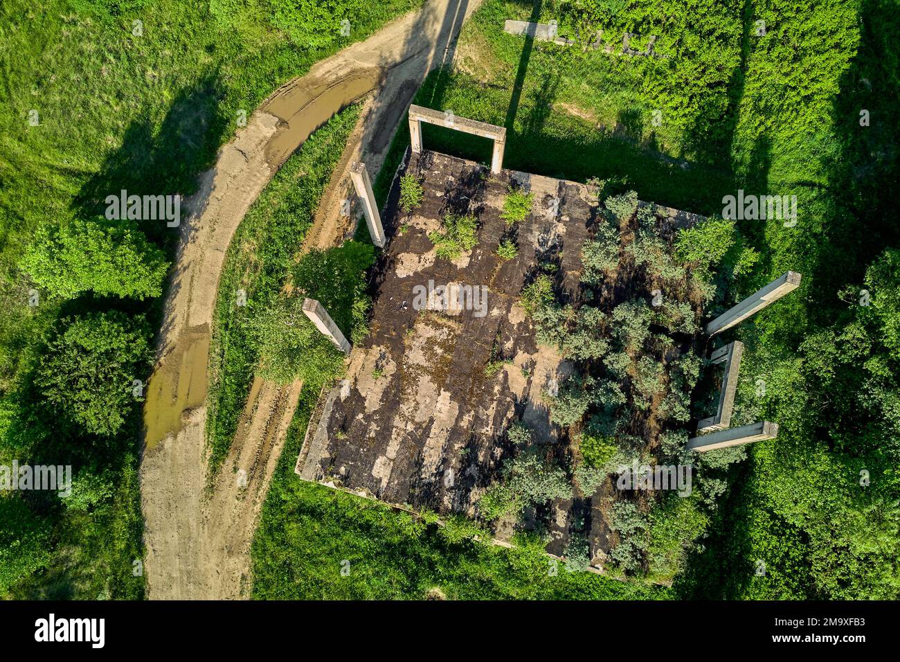 Aerial view of an abandoned building in the middle of nature overgrown ...