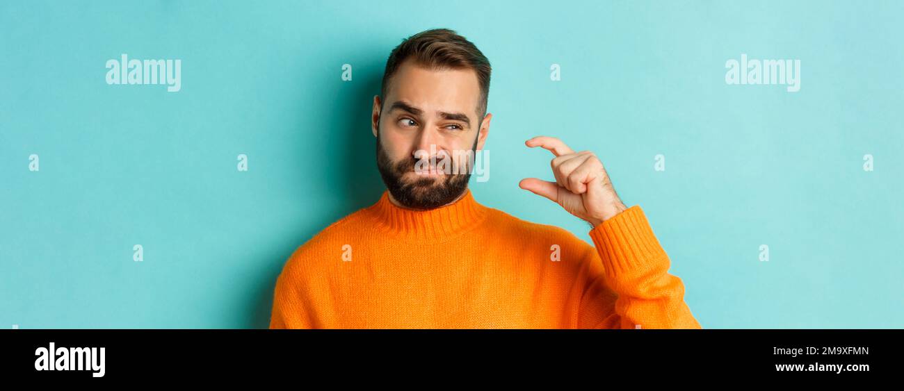 Close-up of caucasian man showing small or little with fingers ...