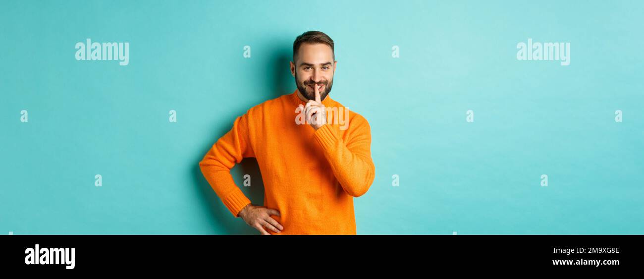 Happy man asking keep voice down, shushing and smiling, prepare ...