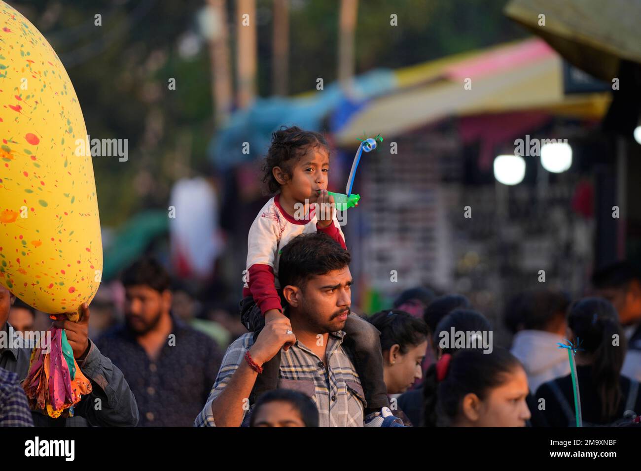 A child rides on the shoulders of a man during the annual Jhiri Fair at ...