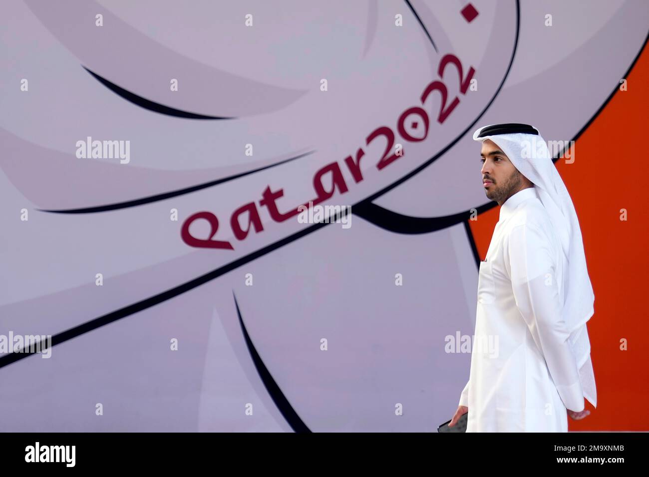 A Qatari man walks in front of a billboard showing an illustration of ...