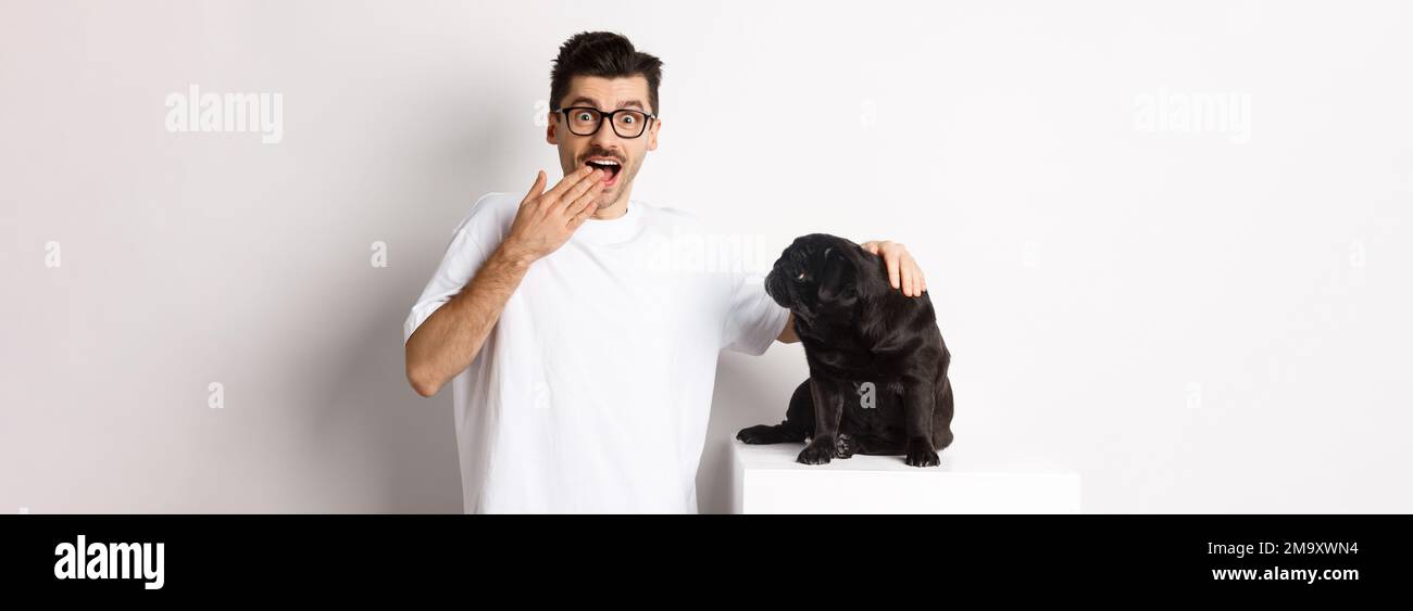 Image of surprised and happy dog owner pet his dog and staring at ...