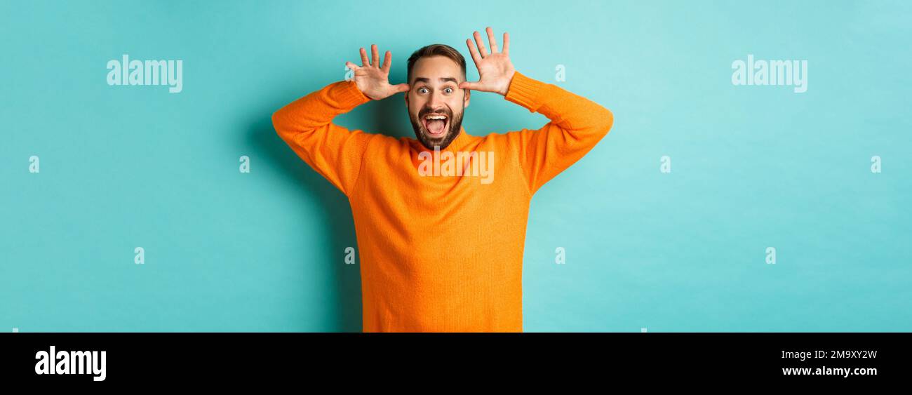 Image of handsome caucasian man making funny faces, mocking someone and ...