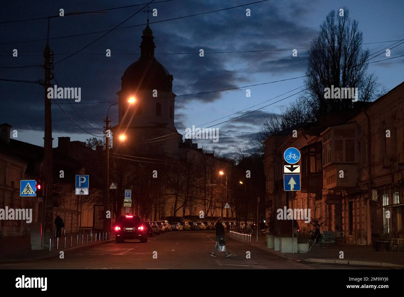 A woman crosses a street during a blackout in Kyiv, Ukraine, Friday ...