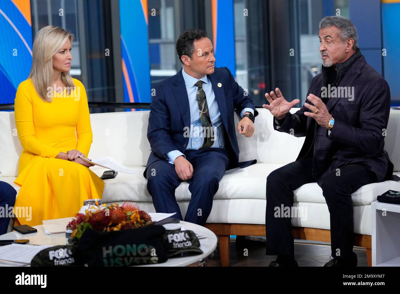 Ainsley Earhardt, left, Brian Kilmeade and Sylvester Stallone appear on "Fox & Friends" on ...