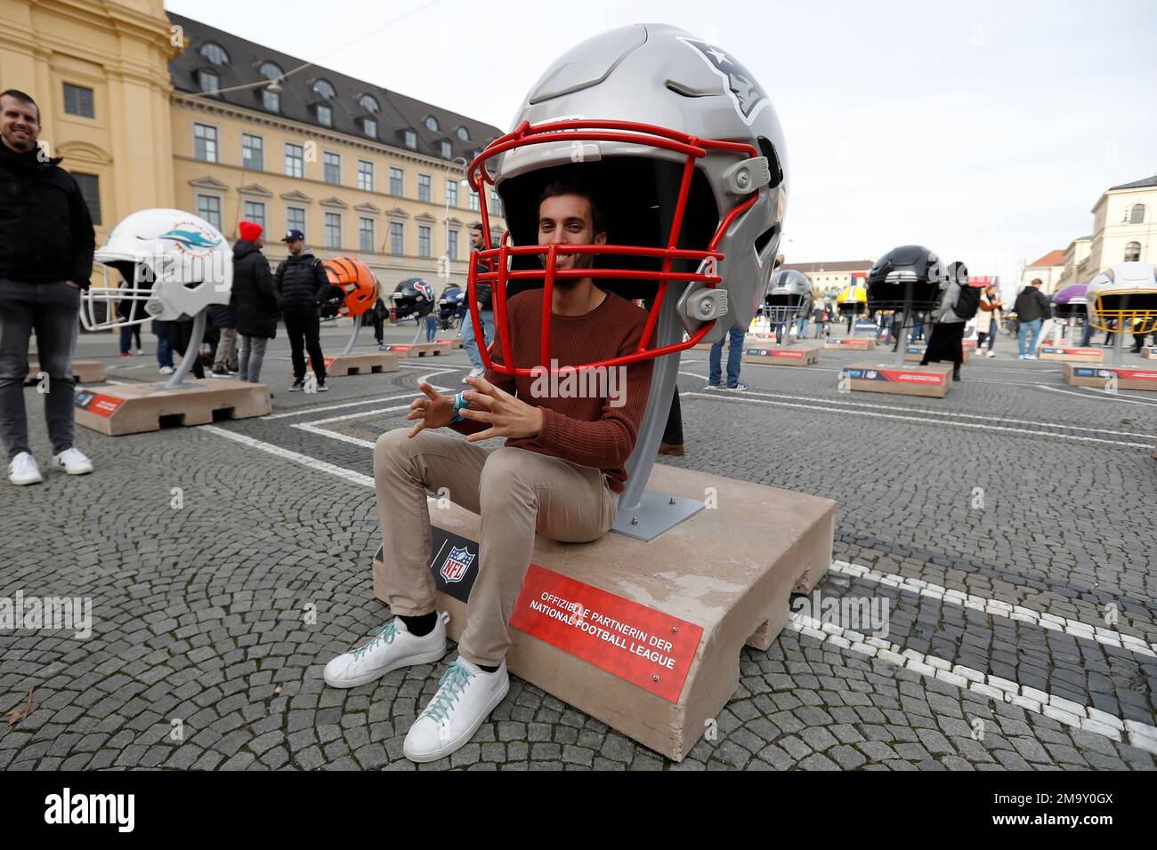 A fan poses for a photo inside a large New England Patriots helmet at ...